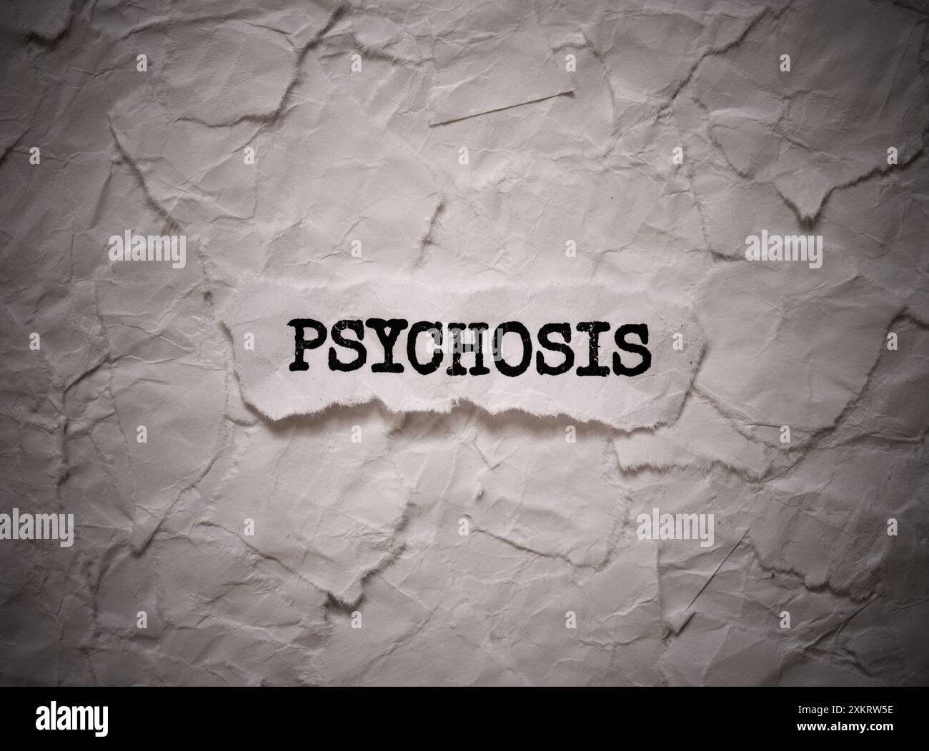 Crumpled piece of paper with word Psychosis on a torn white paper ...