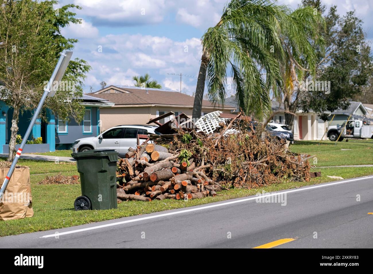Heaps of limbs and branches debris from hurricane winds on street side ...