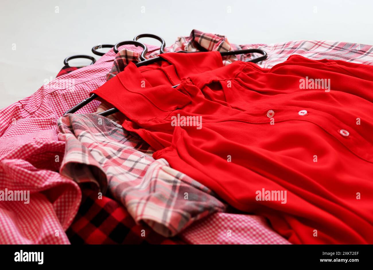 Clothes in shades of red and different prints still on the hanger ...