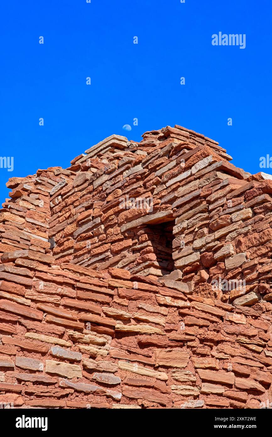 Rising moon peeks out above multi-storied sandstone block masonry ...