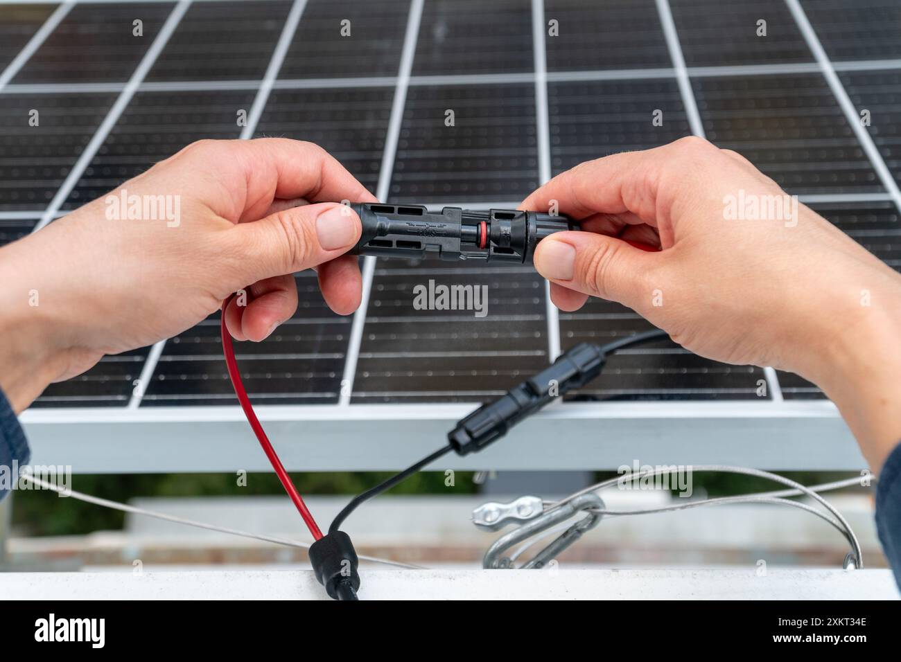 Close up of technician's hands connecting mc4 connectors over the solar ...