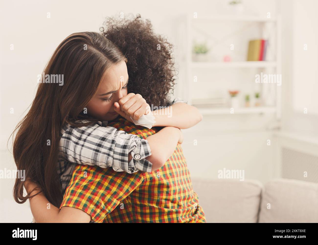 Woman hugging her depressed friend at home, closeup. Young girl ...