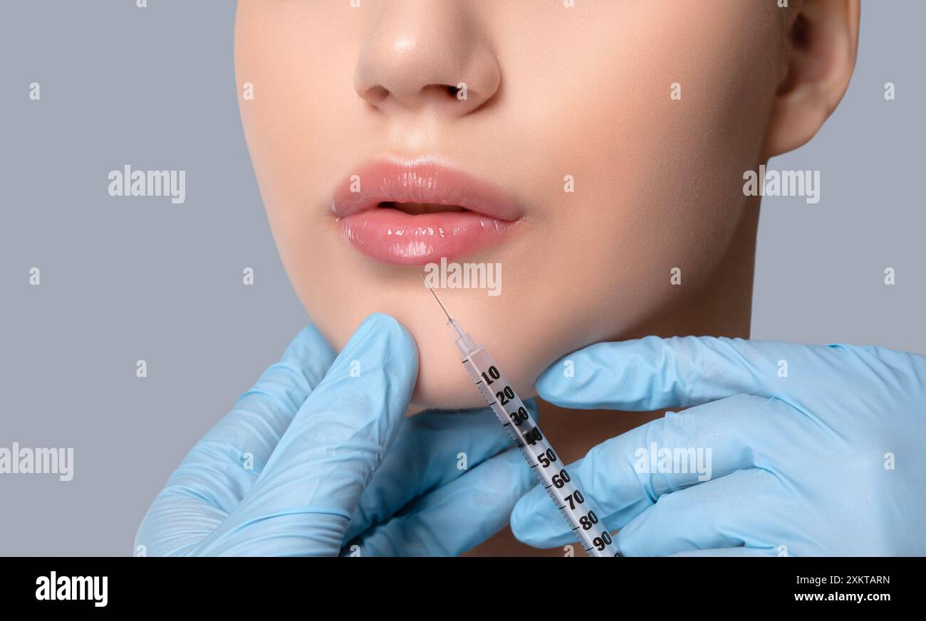 Cosmetologist does injections on the lips and in the nasolabial folds ...