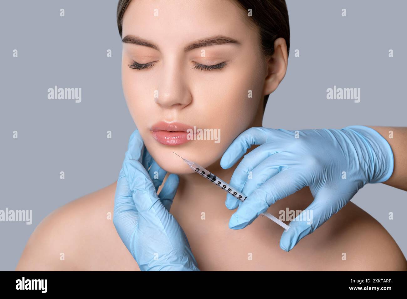 Cosmetologist does injections on the lips and in the nasolabial folds ...