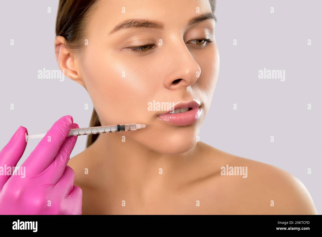 Woman with beautiful clean skin. Cosmetologist does injections for lips ...