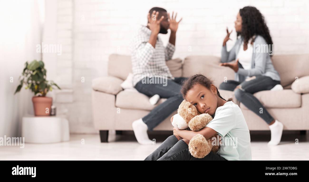 Family problems. Little black girl suffering from parents quarrels ...
