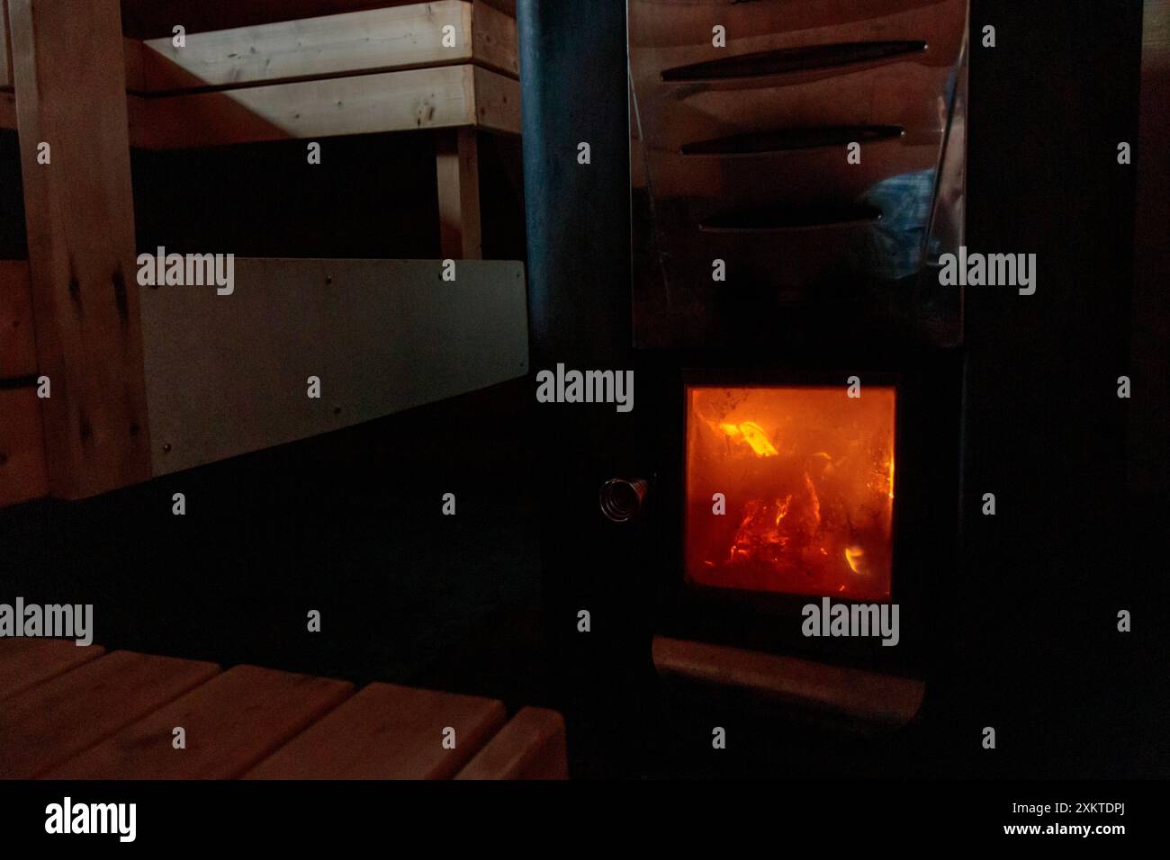 Finnish traditional wood sauna heater with stones and fire. Steam room ...