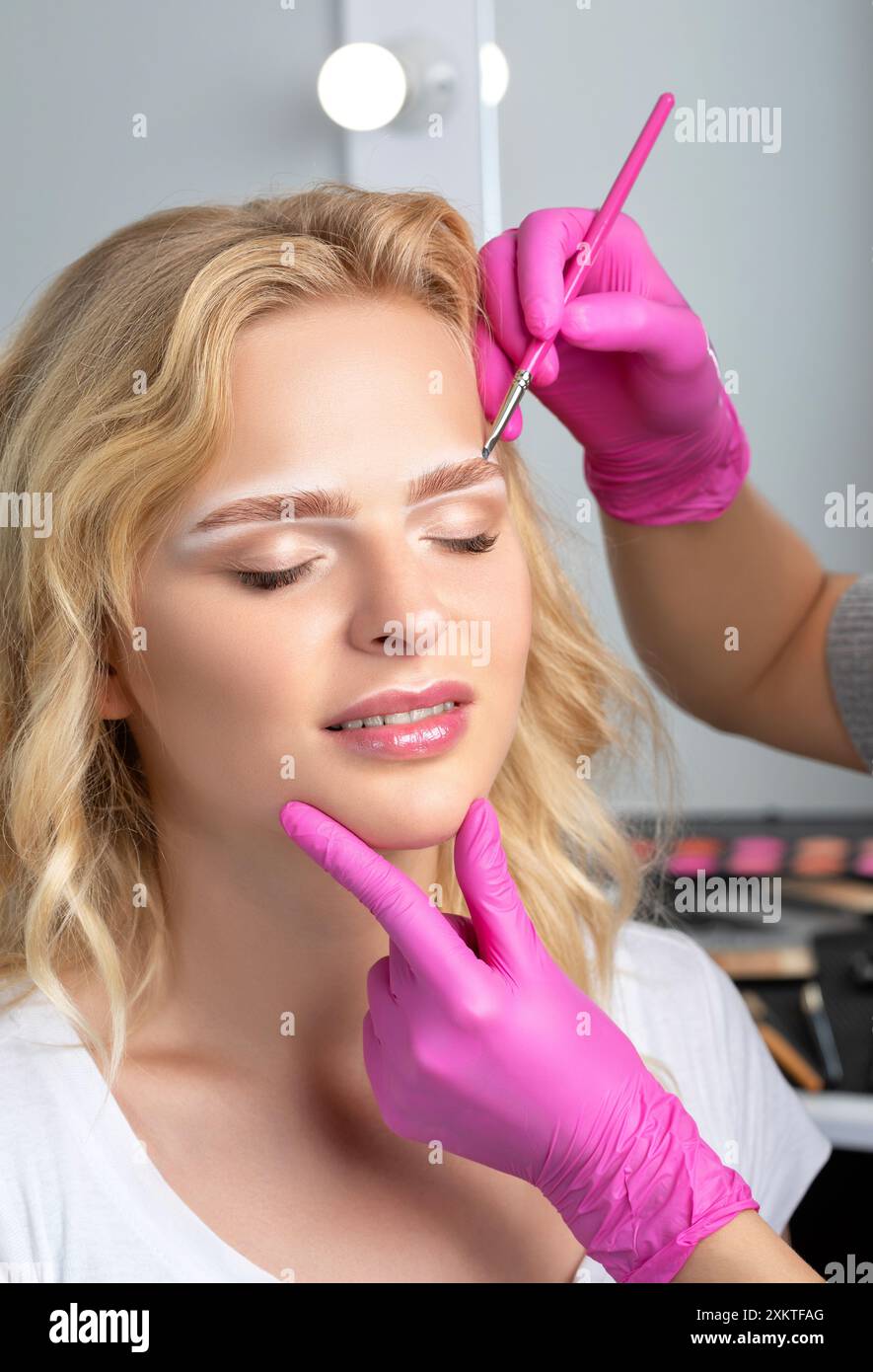 Cosmetologist applying permanent up on hi-res stock photography and ...