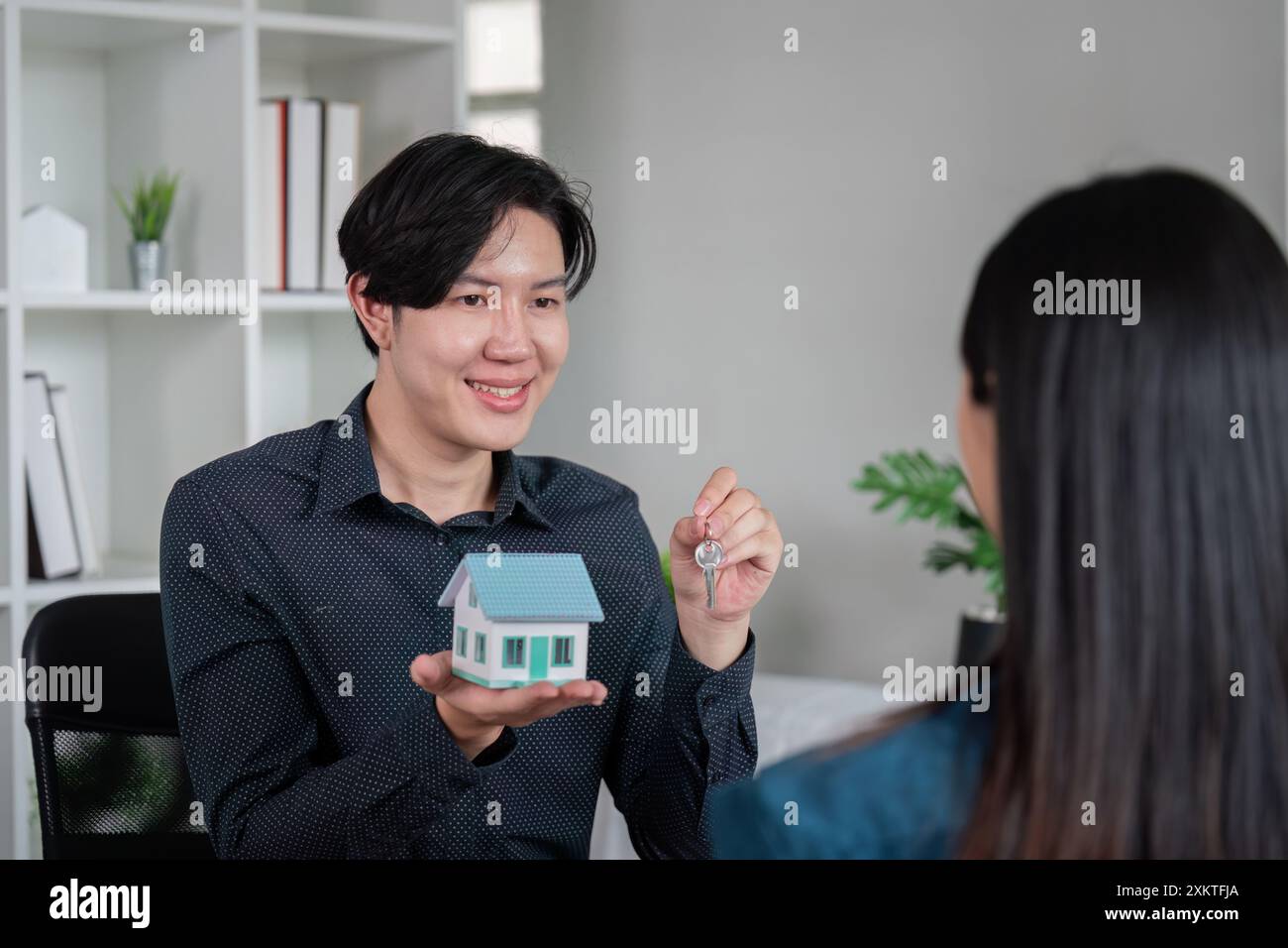 Smiling Real Estate Agent Holding House Model and Key in Office with ...