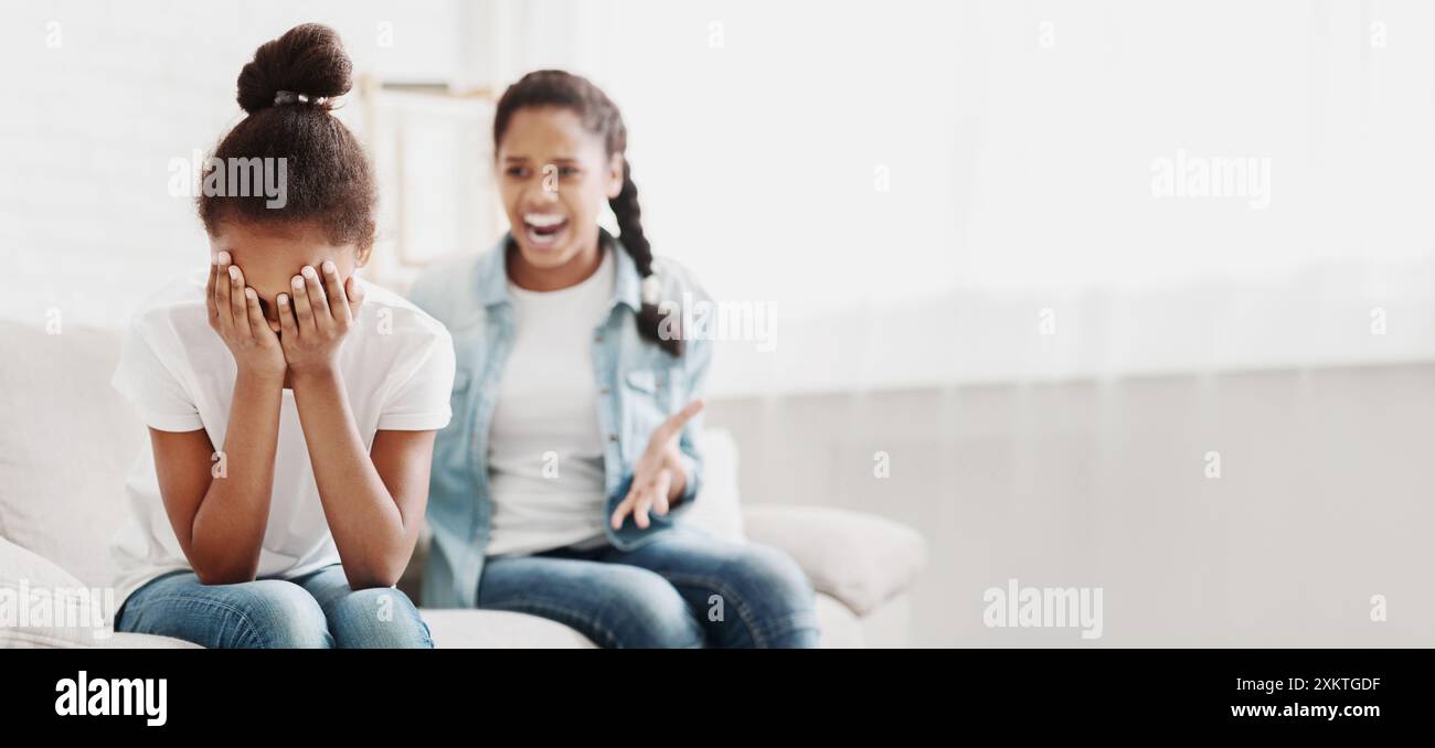 Generation conflict. Furious african girl yelling at her sister, little ...