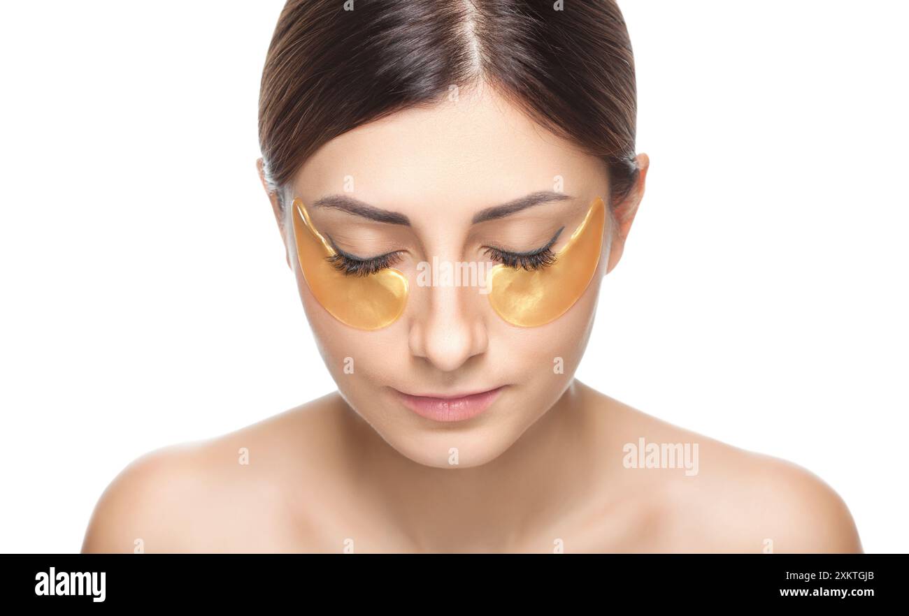Collagen gold patches under the eyes against wrinkles and dry skin on the face of a beautiful ...