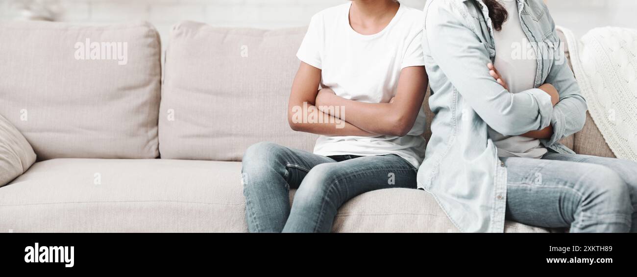 Siblings problem. Cropped image of two african sisters sitting next to ...