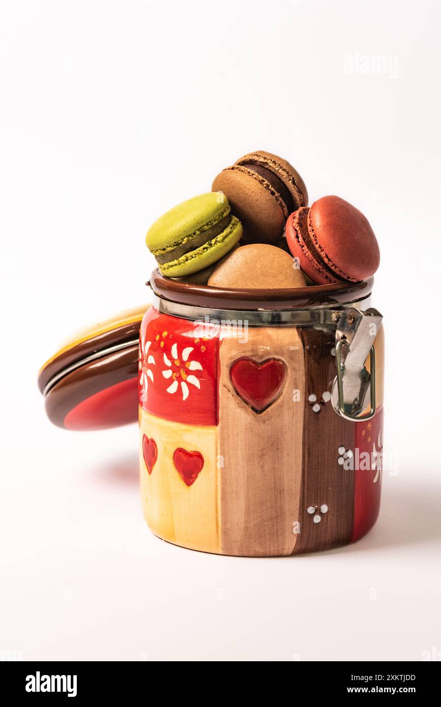 A charming ceramic jar, adorned with a patchwork of red, yellow, and ...