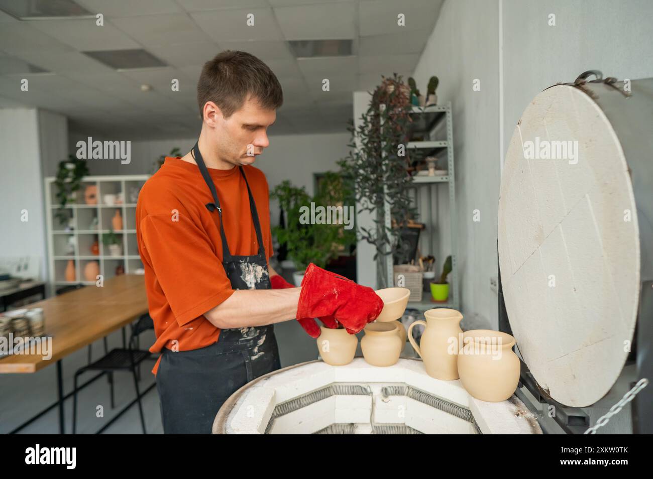 Caucasian man loading ceramic products into a special kiln Stock Photo ...