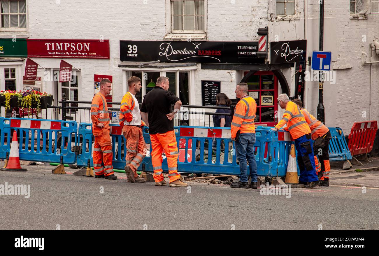 A group of construction workers in high-visibility clothing standing ...