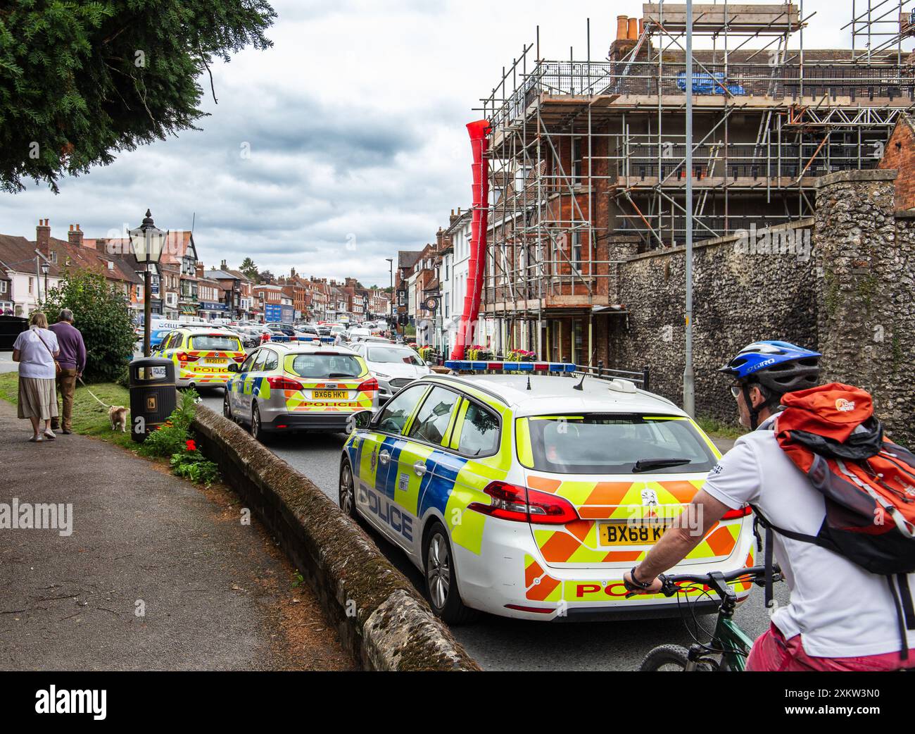 Street scene with multiple police cars queuing along the high street in ...