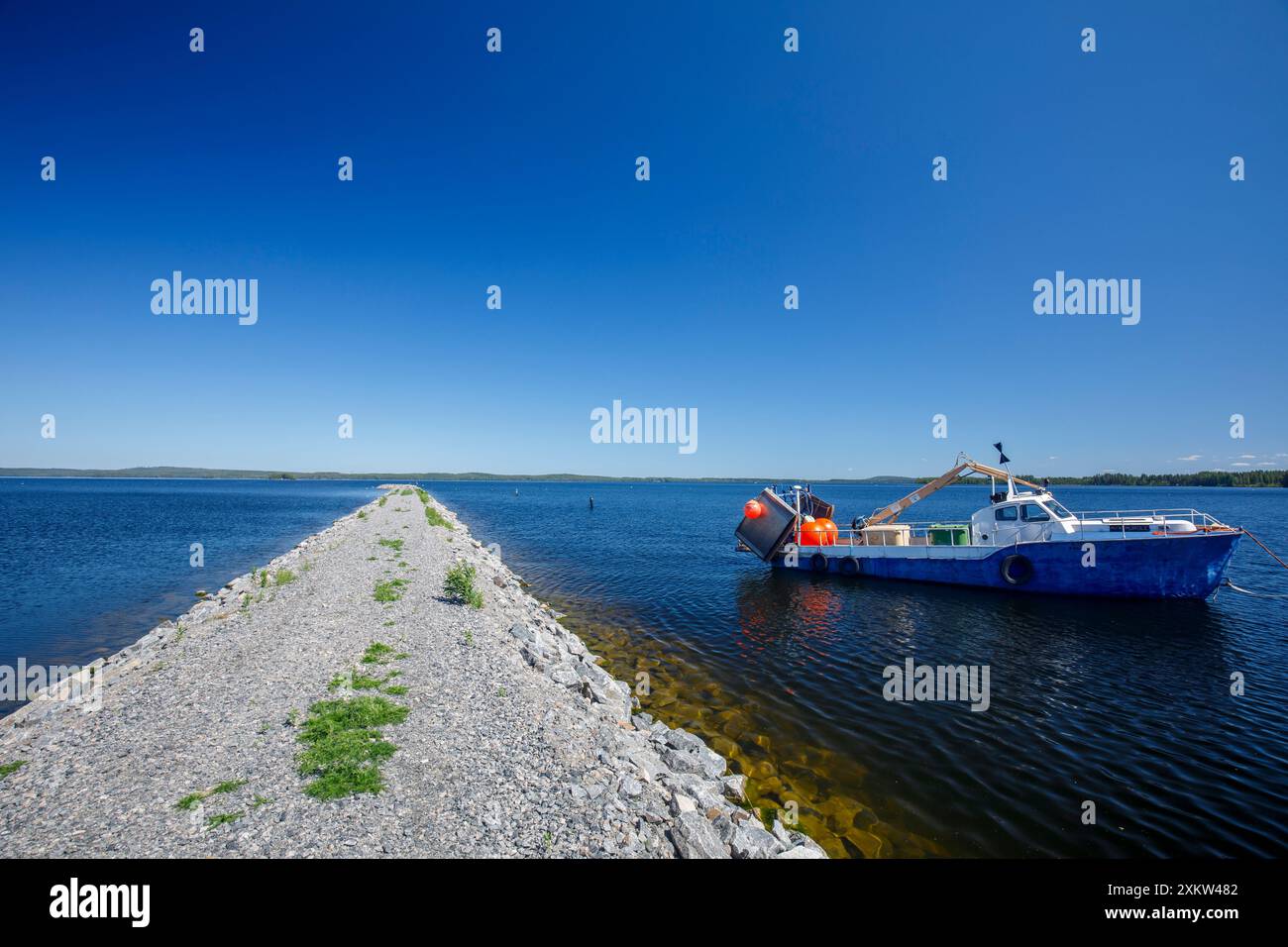 Small inland lake fishing trawler anchored behind breakwater at lake ...