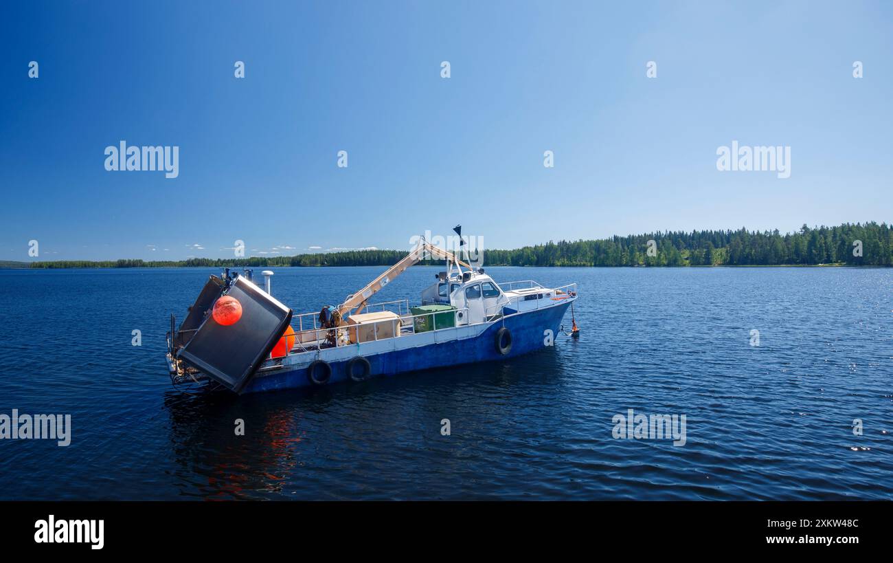 Small inland lake fishing trawler anchored behind breakwater at lake ...