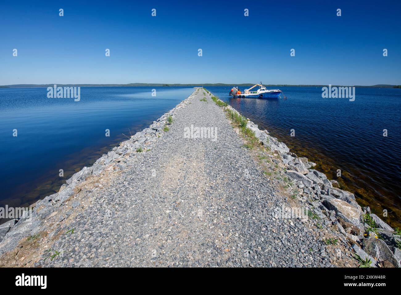Small inland lake fishing trawler anchored behind breakwater at lake ...