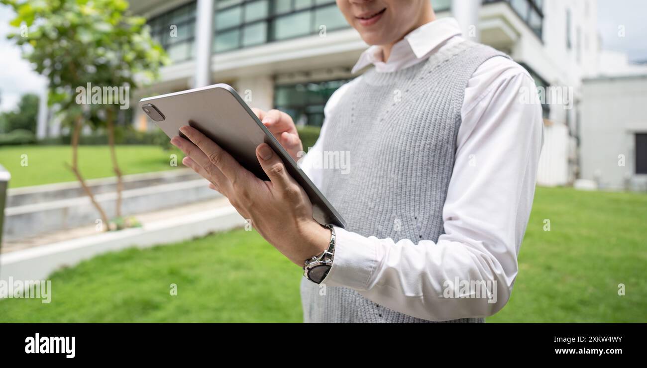 Young Professional Using Tablet Outside Modern Office Building for ...