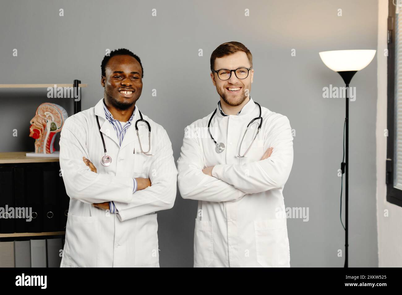 Two men in white lab coats standing together near desk Stock Photo - Alamy