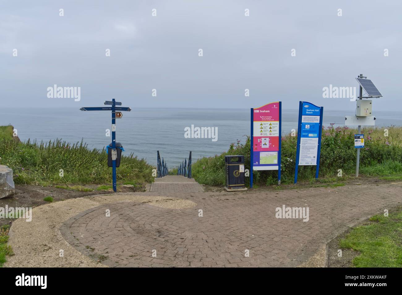 tourist information signs and coastal path marker next to steps leading ...