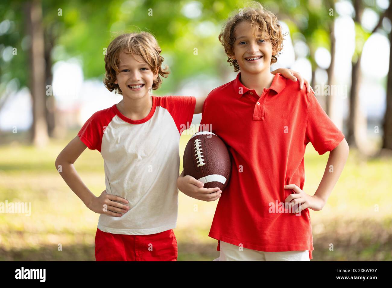 Family playing American football. Kids play rugby in sunny summer park ...