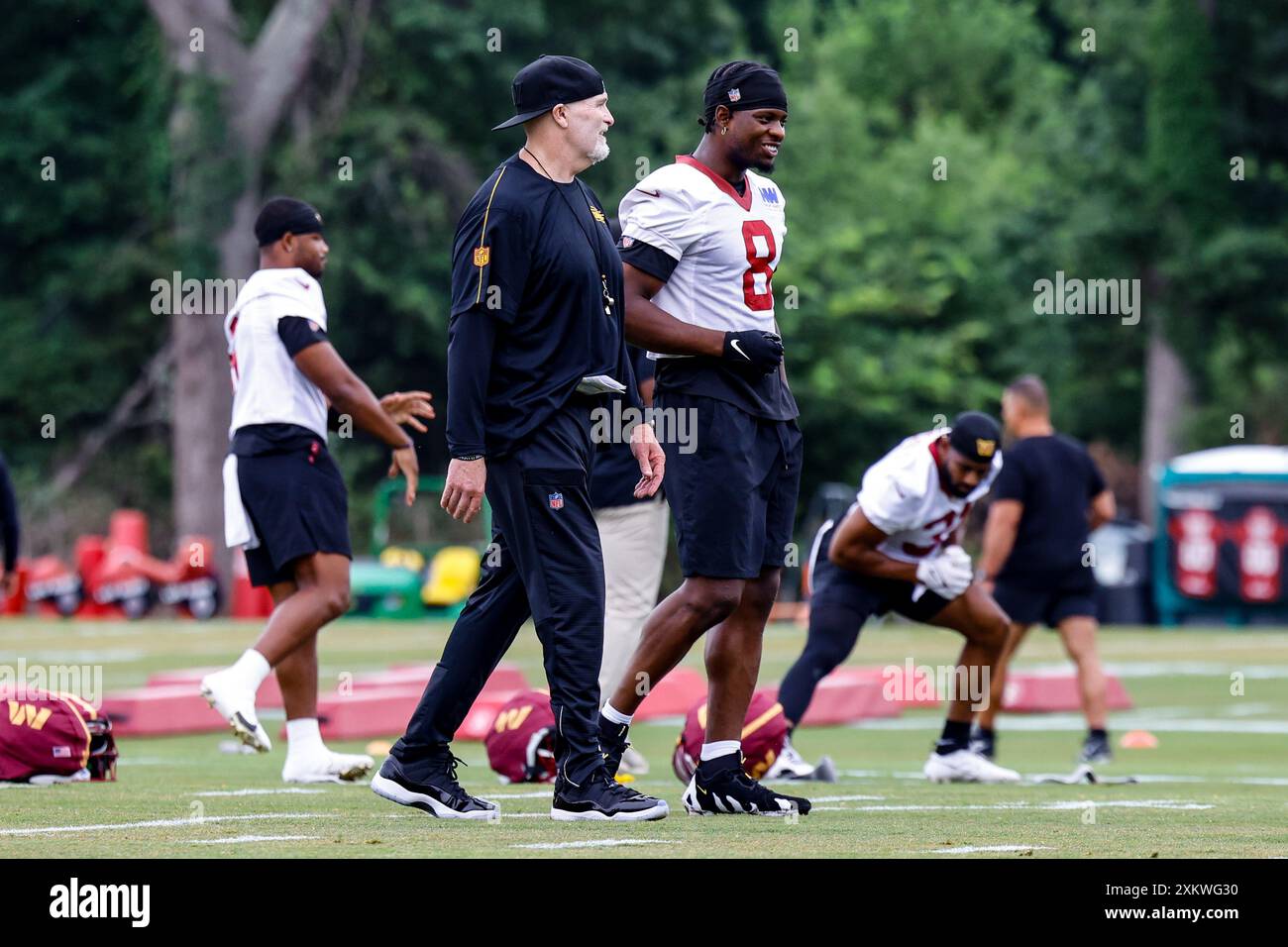Washington Commanders running back Brian Robinson Jr. (8) talking with head coach Dan Quinn ...
