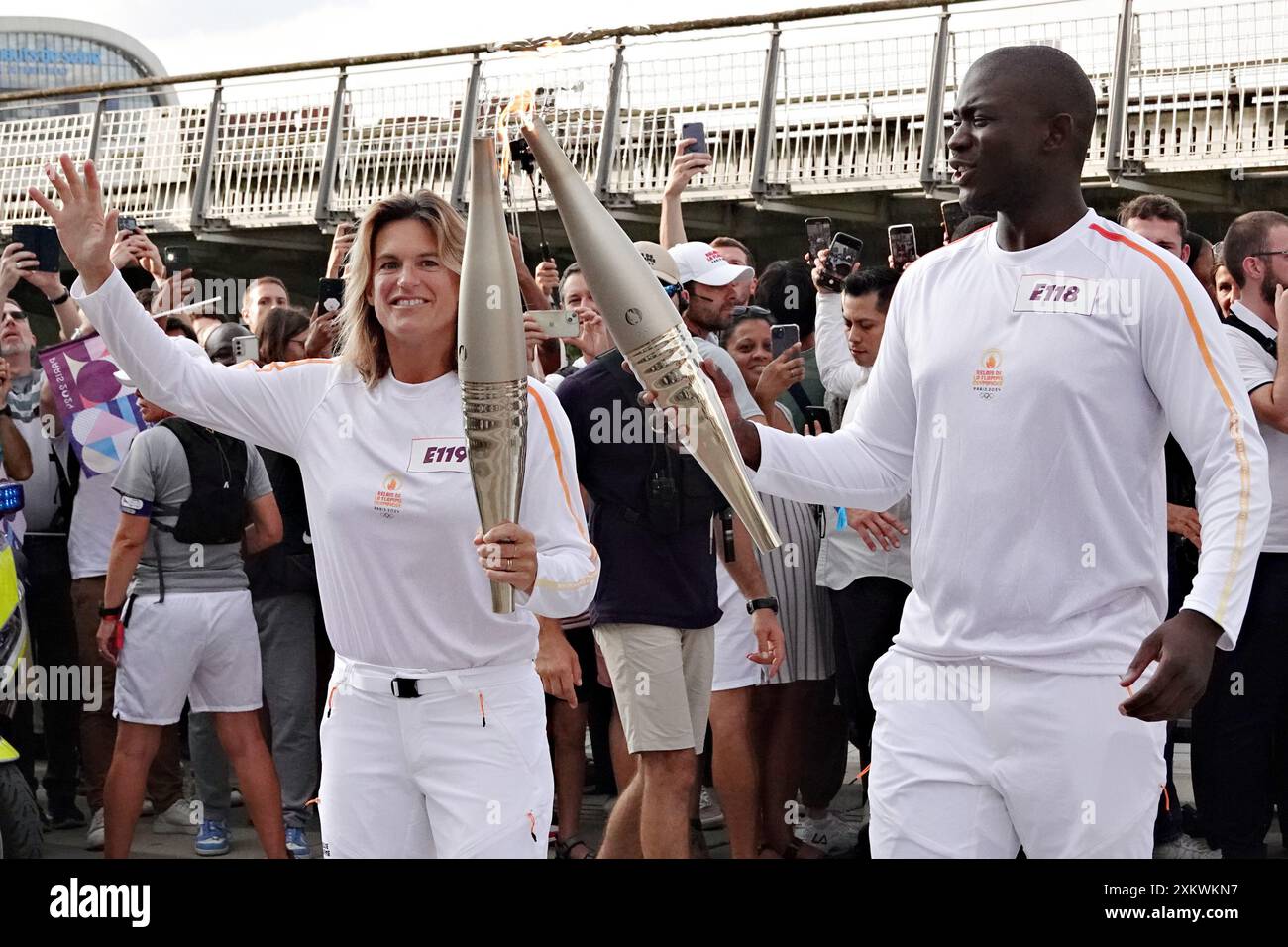 Paris, France. 24th July, 2024. Torch bearers hand off the Olympic ...