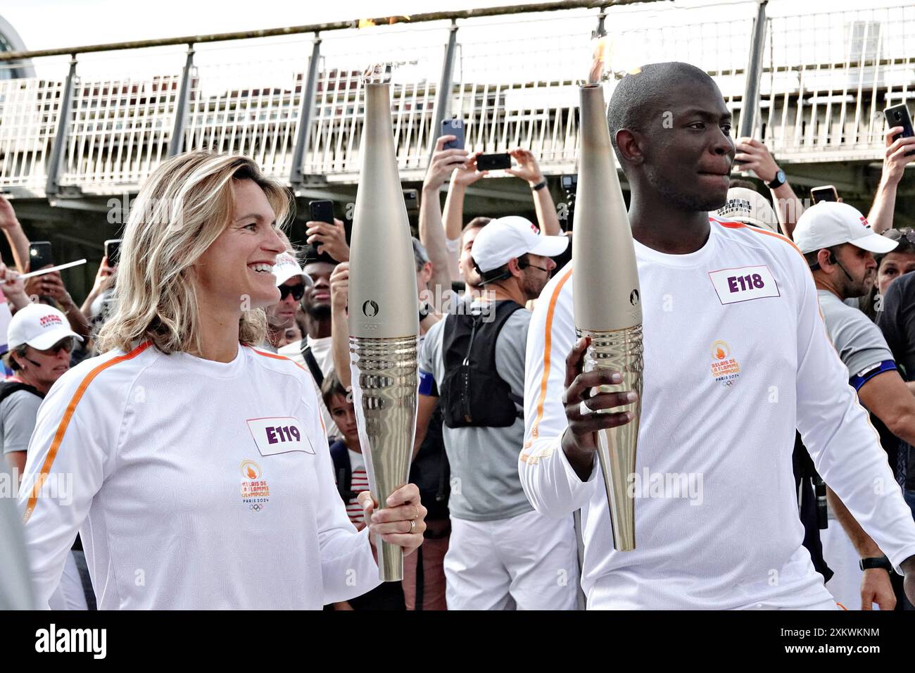 Paris, France. 24th July, 2024. Torch bearers hand off the Olympic ...