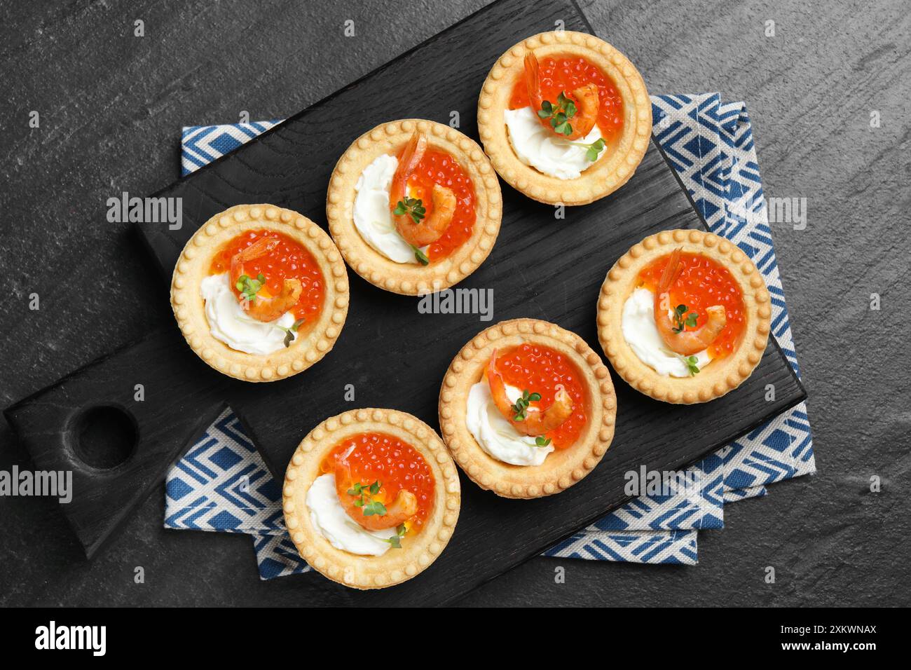Delicious canapes with shrimps, red caviar and cream cheese on dark ...