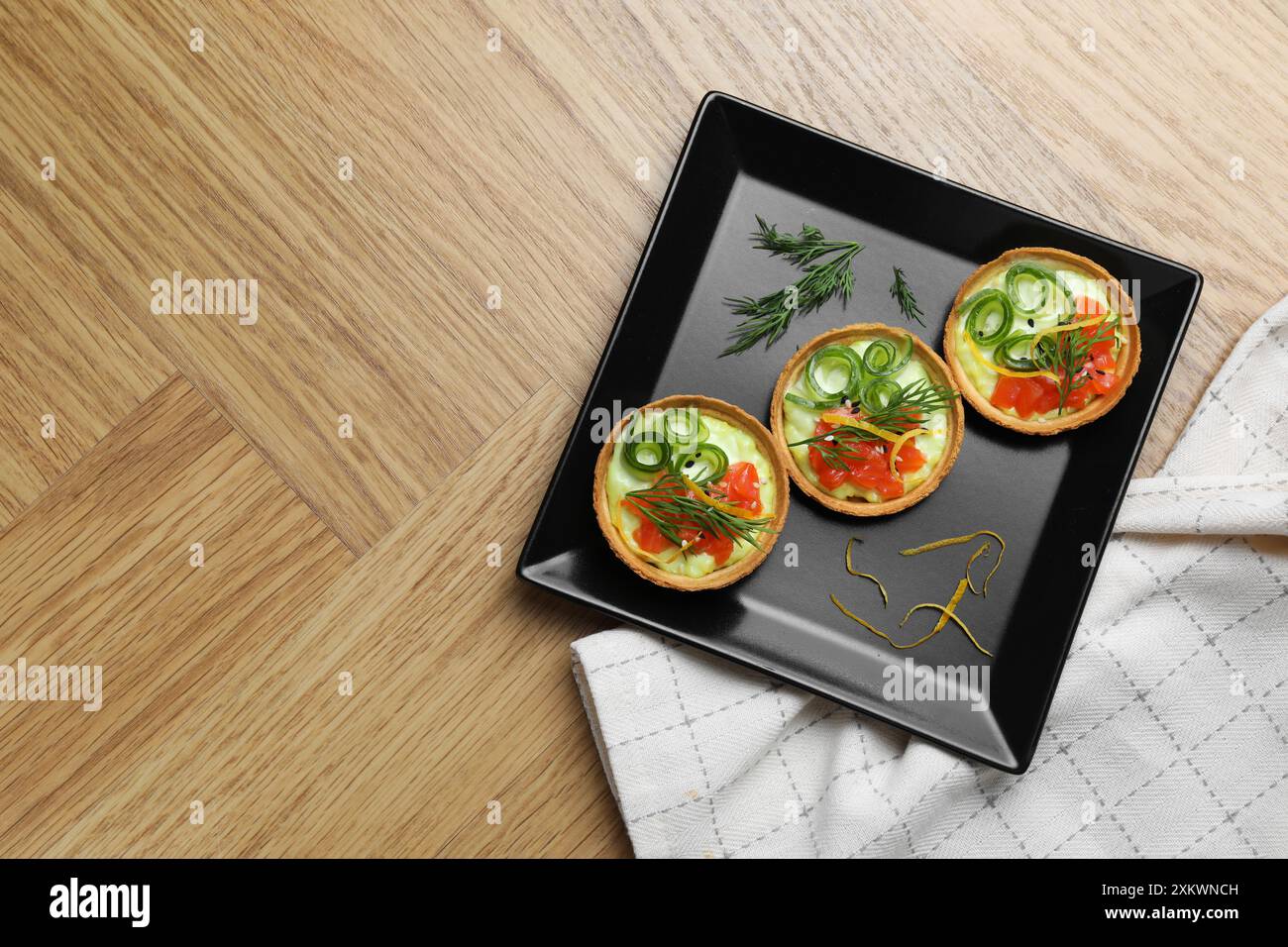 Delicious canapes with salmon on wooden table, top view. Space for text ...