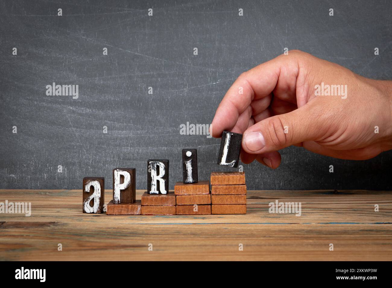 APRIL. Wooden letters, alphabet blocks on steps. development and growth ...