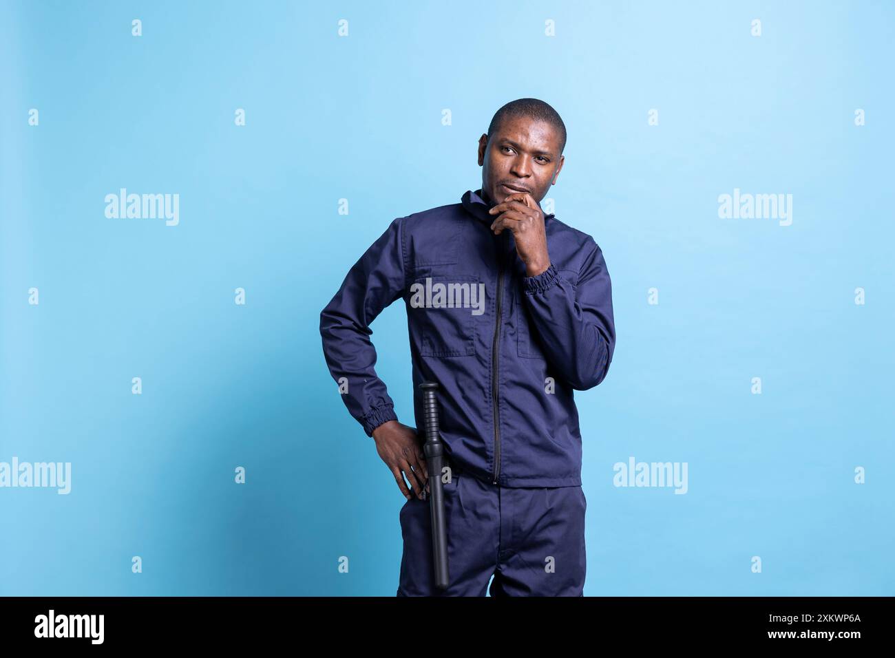 Pensive security guard in uniform with baton thinking about his ...