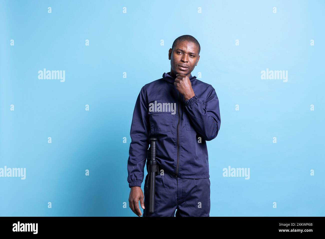 Thoughtful security personnel with uniform and baton thinking of ways ...