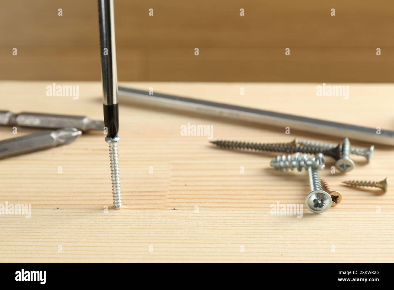 Screwing screw into wooden plank with bits, closeup Stock Photo - Alamy
