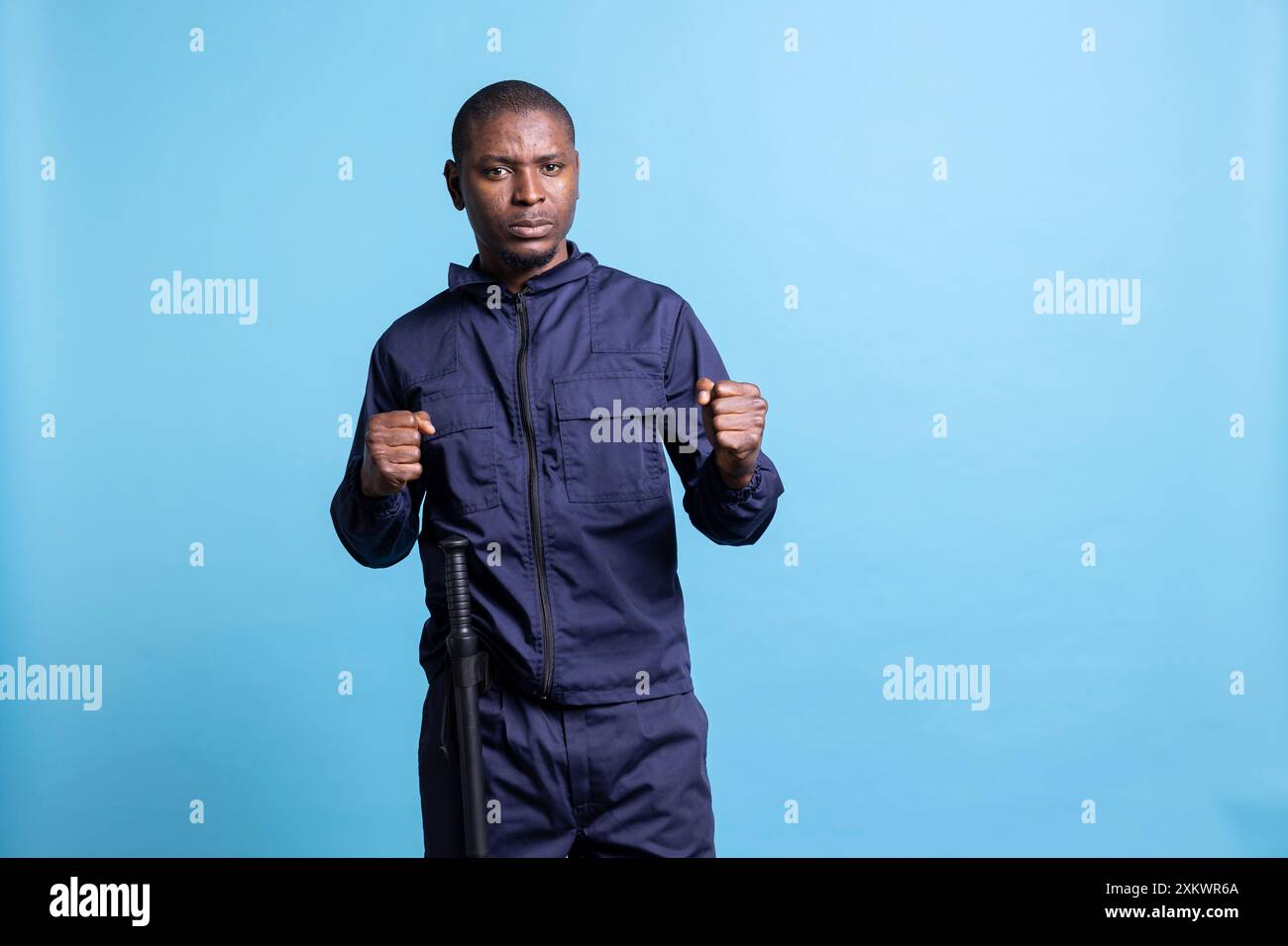 Professional security guard posing with clenched fists in studio, ready ...