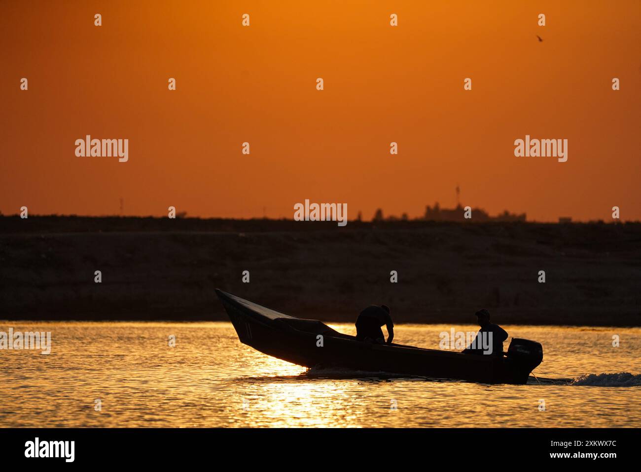 Mosul, Iraq. 22nd July, 2024. A fisherman sits on his boat on the Mosul ...