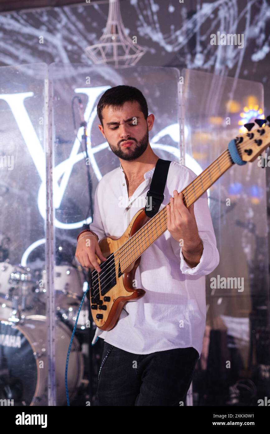 guy musician plays the electric guitar at a concert under stage ...