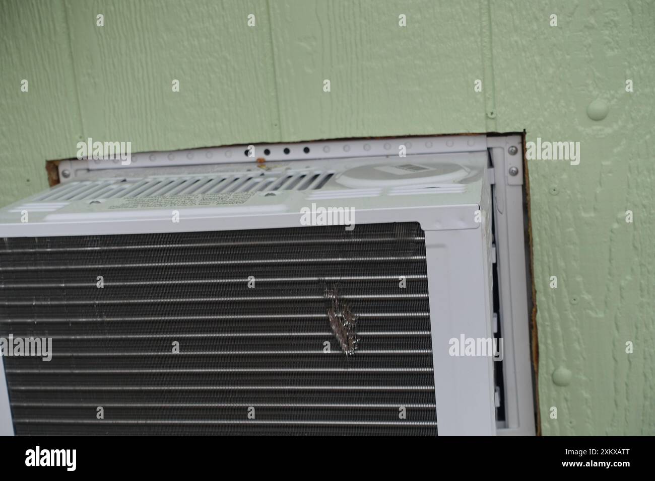 A window mounted AC unit fitted in a wall opening Stock Photo - Alamy