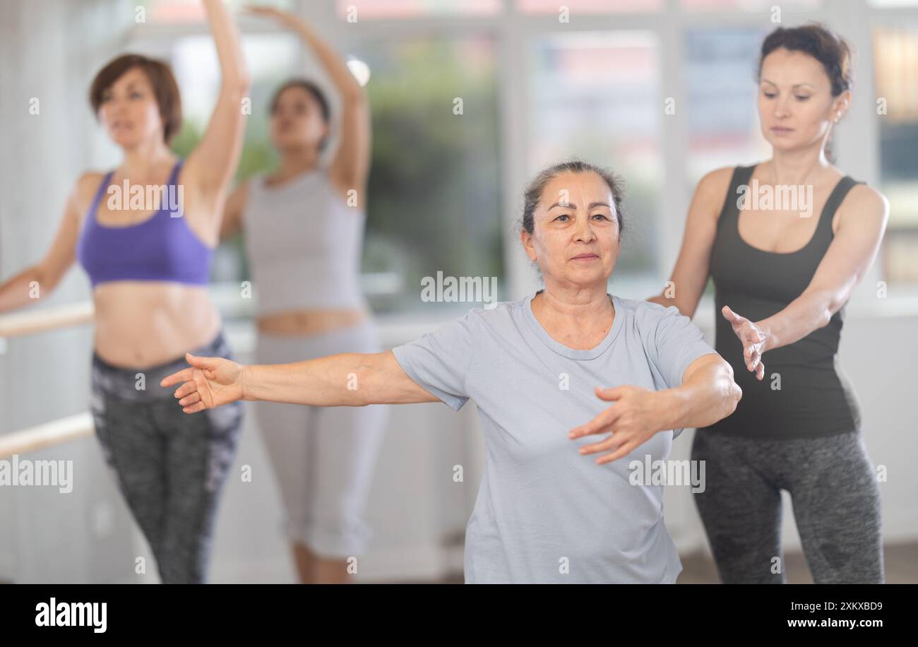 Ballet choreographer instructing senior woman in basic ballet ...
