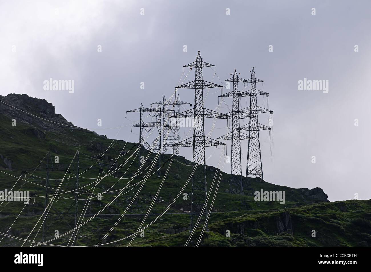 Electricity pylons amidst clouds at the Nufenen Pass in the Swiss Alps ...