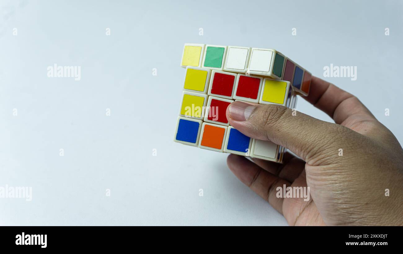 Colorful scrambled 4x4 cube being held in hand isolated on white ...
