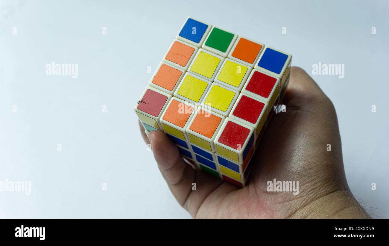Colorful scrambled 4x4 cube being held in hand isolated on white ...