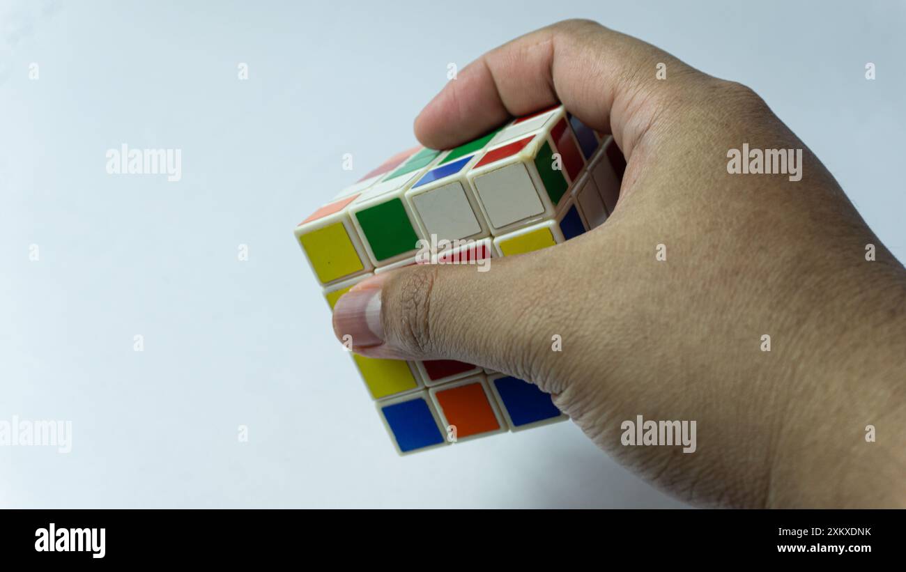 Colorful scrambled 4x4 cube being held in hand isolated on white ...