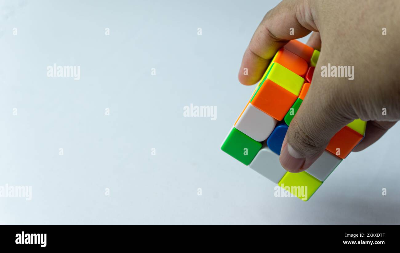 Colorful scrambled 3x3 cube being held in hand isolated on white ...