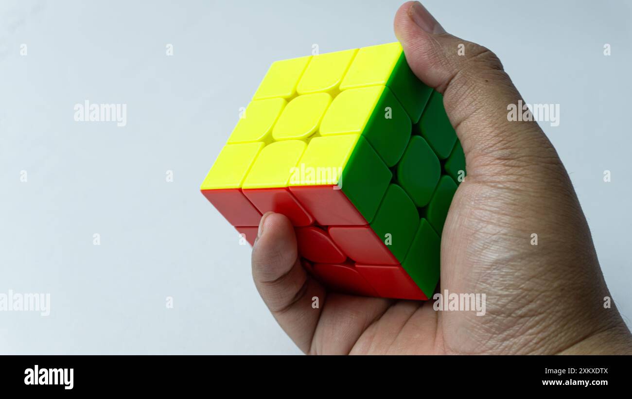 Colorful completed solving 3x3 cube being held in hand isolated on ...