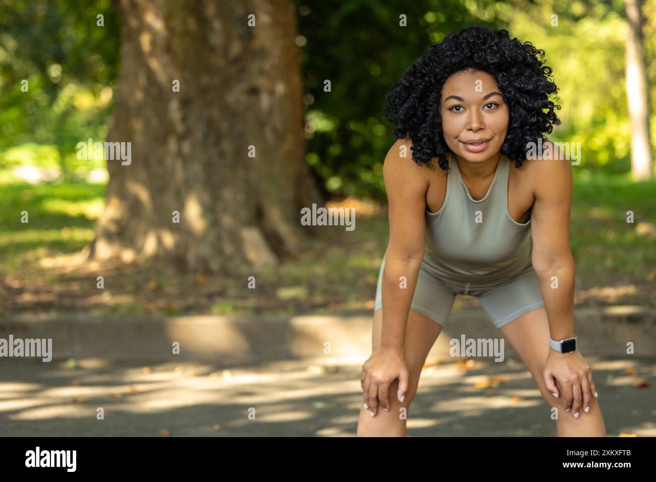 Woman exercising in a park and having a short pause Stock Photo - Alamy