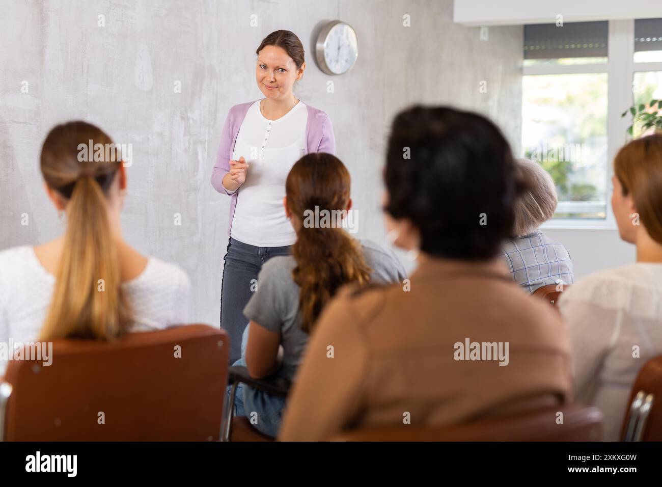 Female teacher giving lecture to group of students in classroom Stock ...