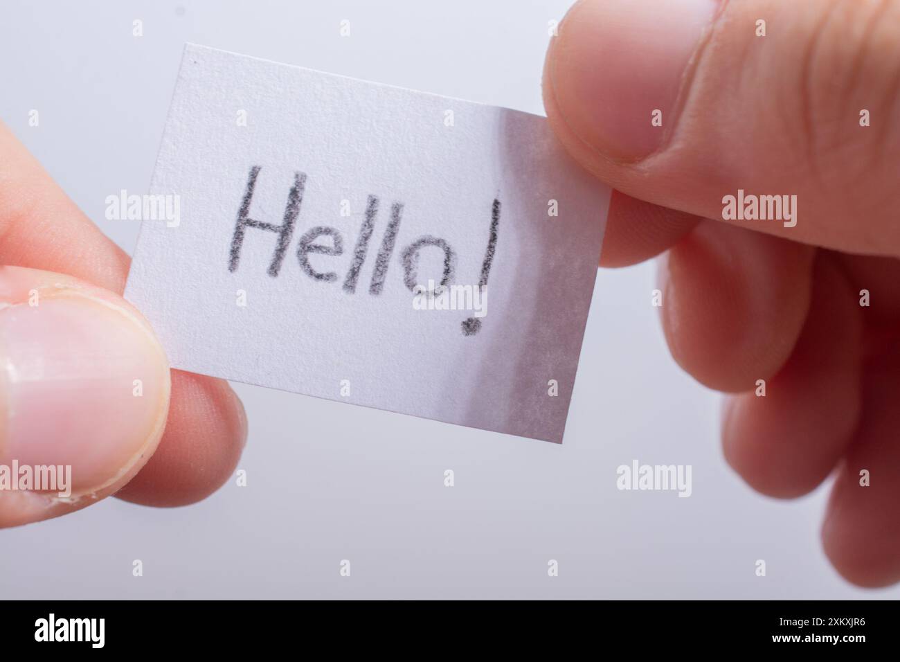 Hand holding notepaper with HELLO wording on white background Stock ...